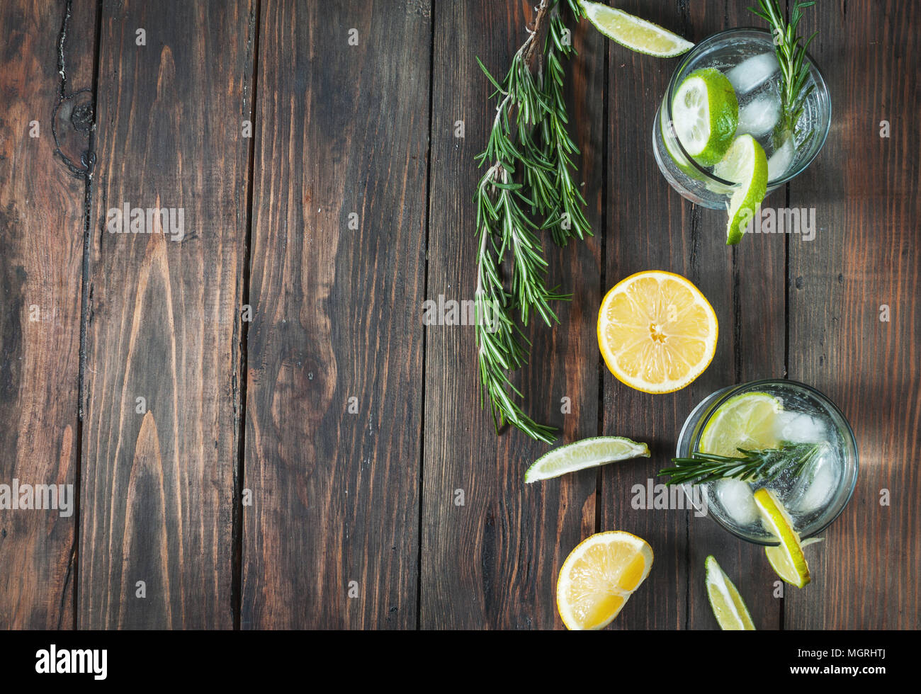 Alcoholic drink gin tonic cocktail with lemon, rosemary and ice on ...