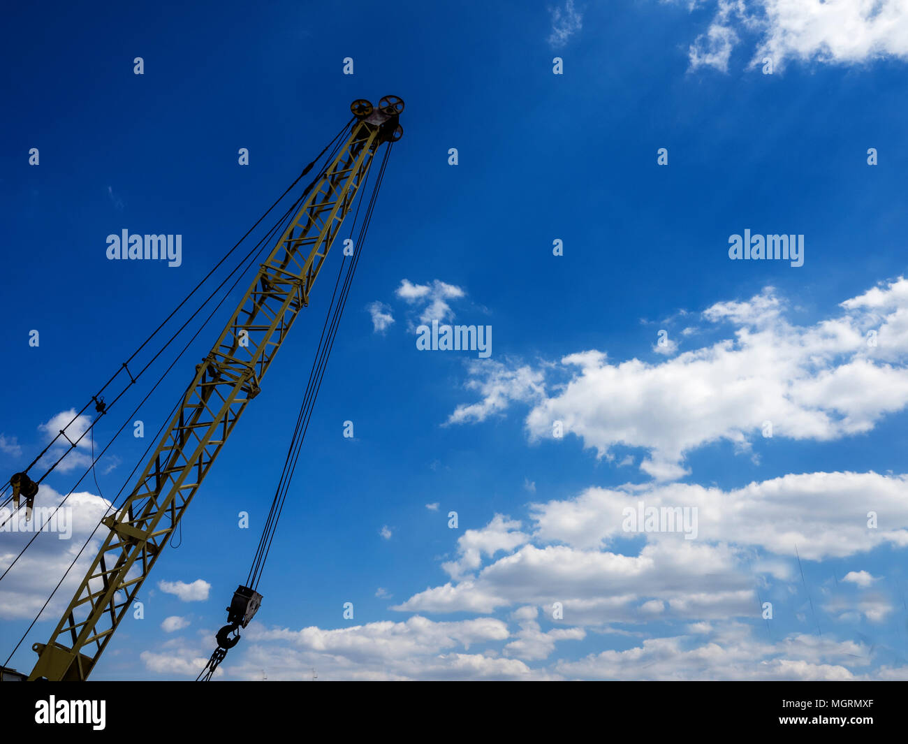 Crane on blue sky background with clouds Stock Photo - Alamy