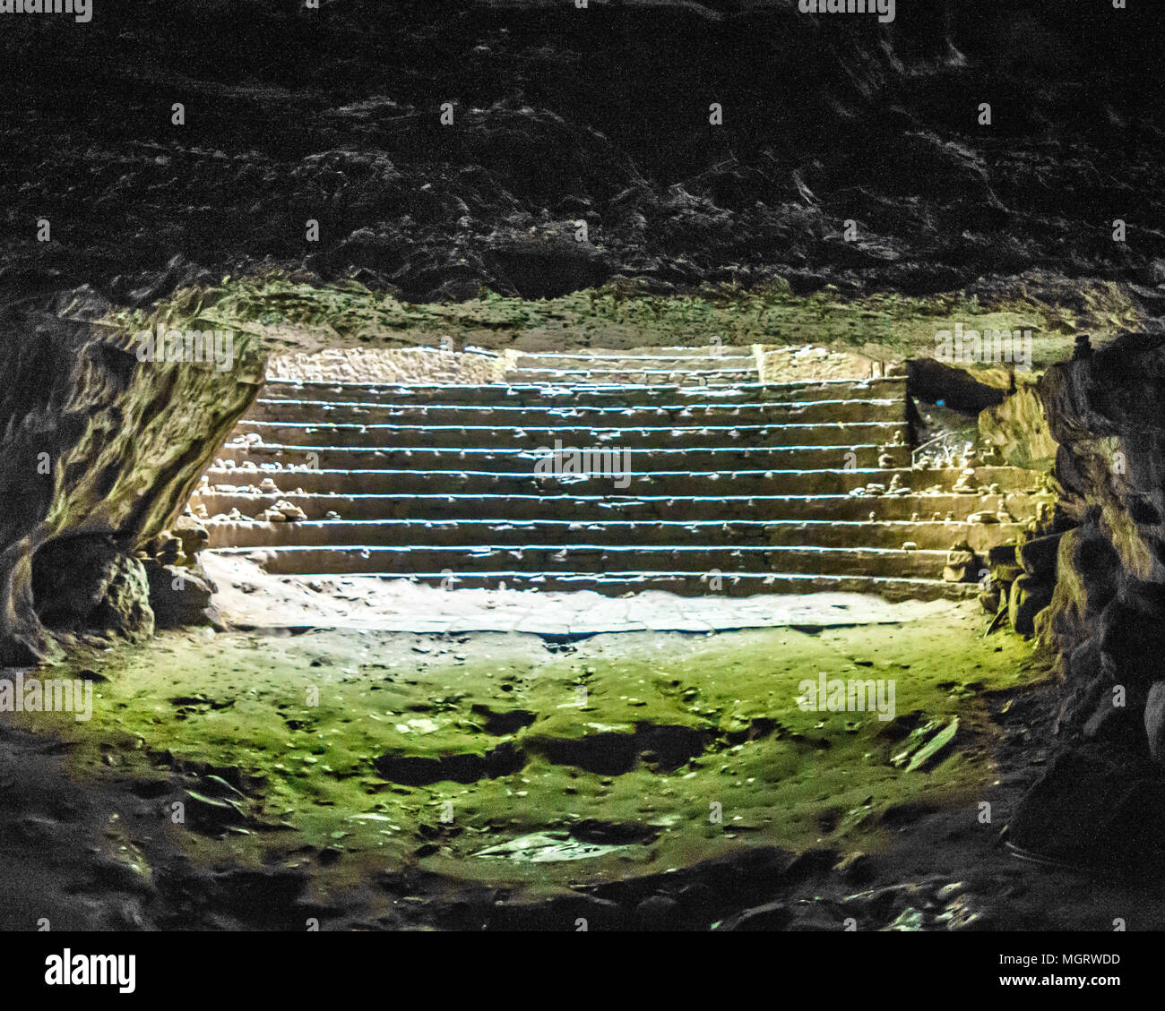 Stairs of a cave entrance, very dark and wet low light muddy very much ...