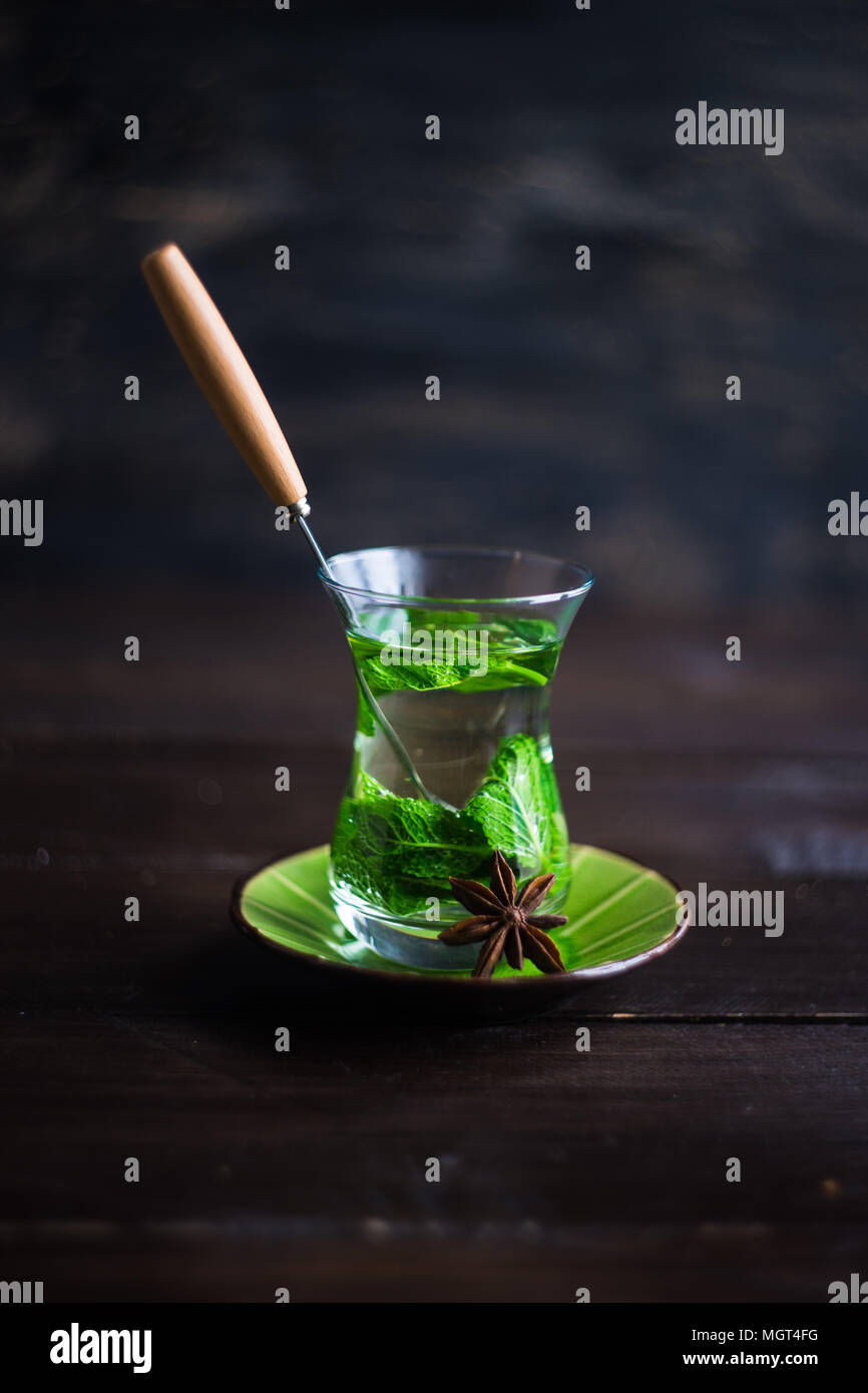 Traditional mint tea in glass cup on dark wooden table with copy space ...