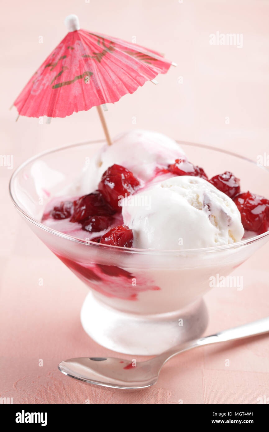 Sundae with cherry jam and drink umbrella Stock Photo - Alamy