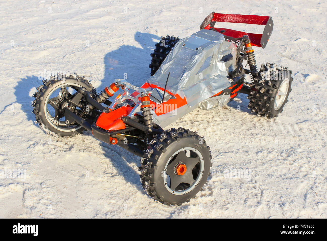 Radio-controlled model racing car with a gasoline engine in the snow ...