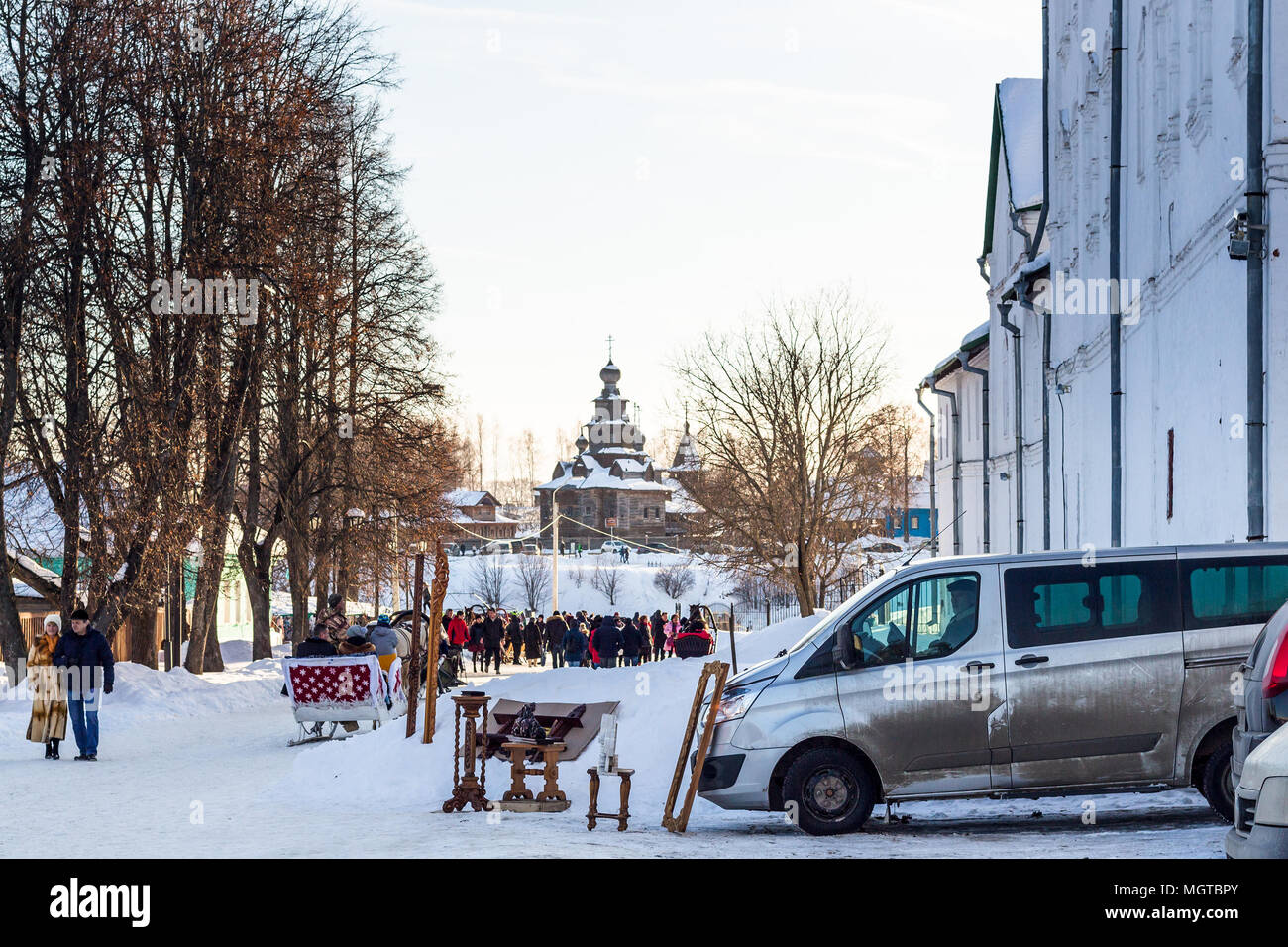 SUZDAL, RUSSIA - MARCH 9, 2018; tourists walk to wooden Church of the ...