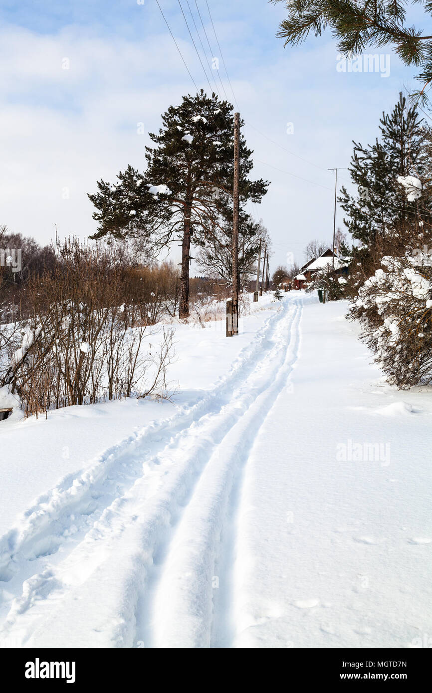 footpath and ski run along little russian village in winter day in ...