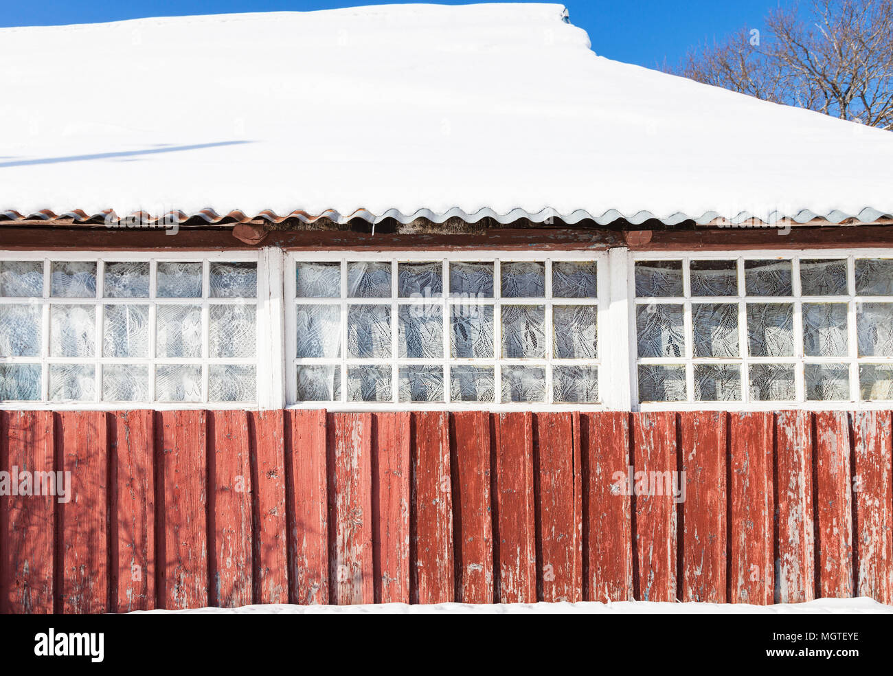 snow-covered veranda of old country house in winter in little village ...