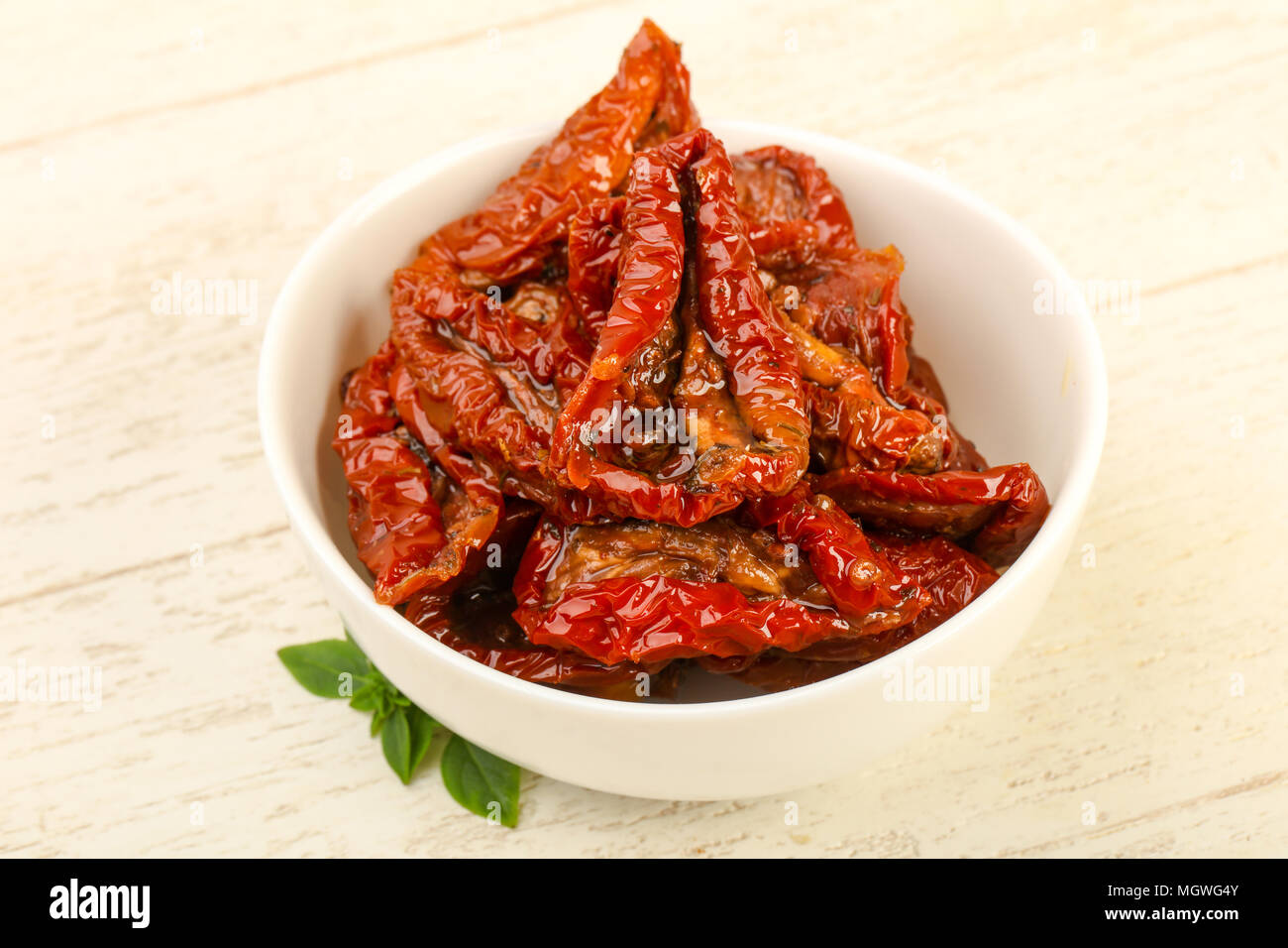 Dried tomato in olive oil with basil leaves Stock Photo - Alamy