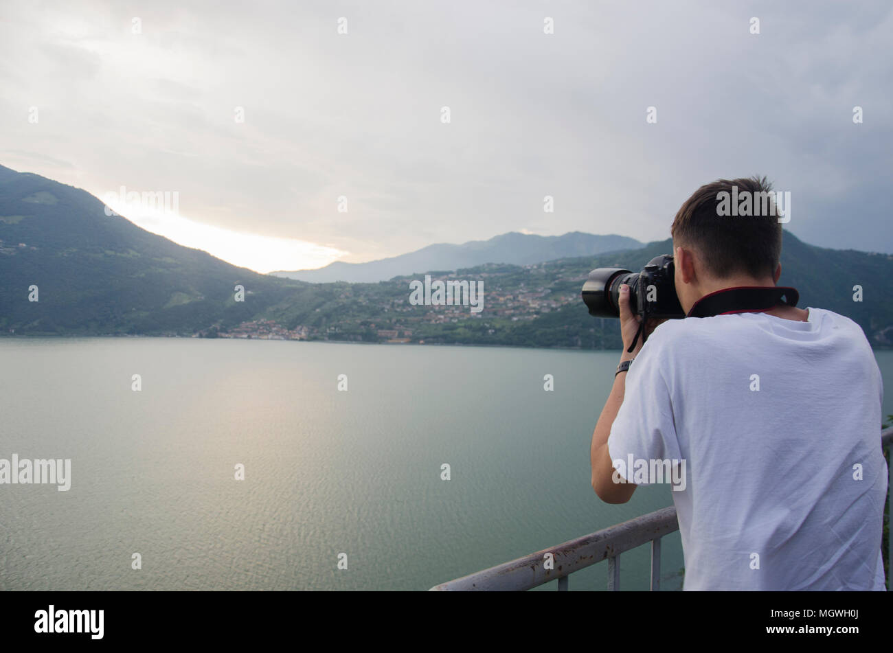Photographer taking a picture at the sunset over the Italian Alps ...