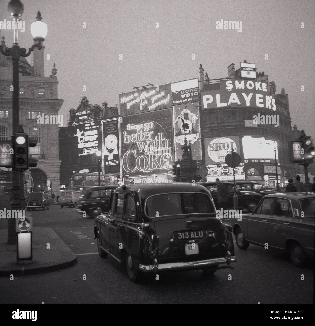 1960s, historical picture of a London taxi and a car waiting at the ...