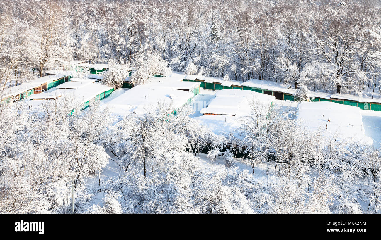 above view of snow-covered garages between urban Timiryazevsky park and ...