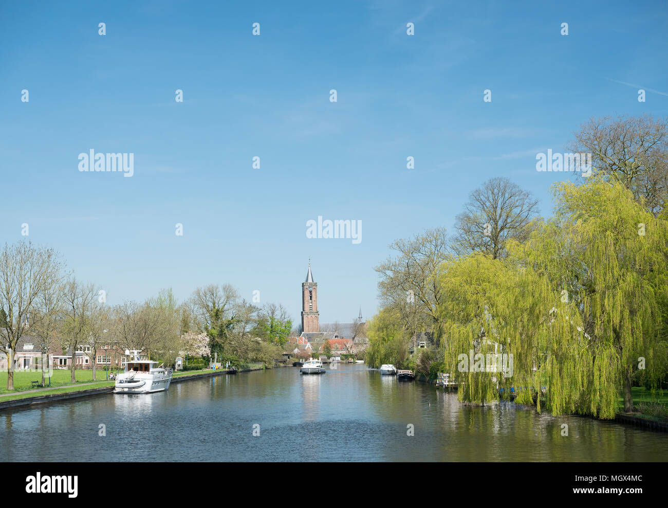 boats and church tower in river vecht near Loenen in dutch province of ...