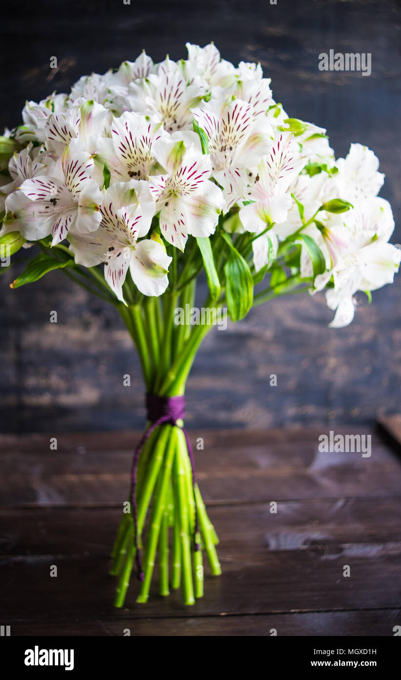 White Lily of the Incas in a bunch on rustic background with copyspace ...