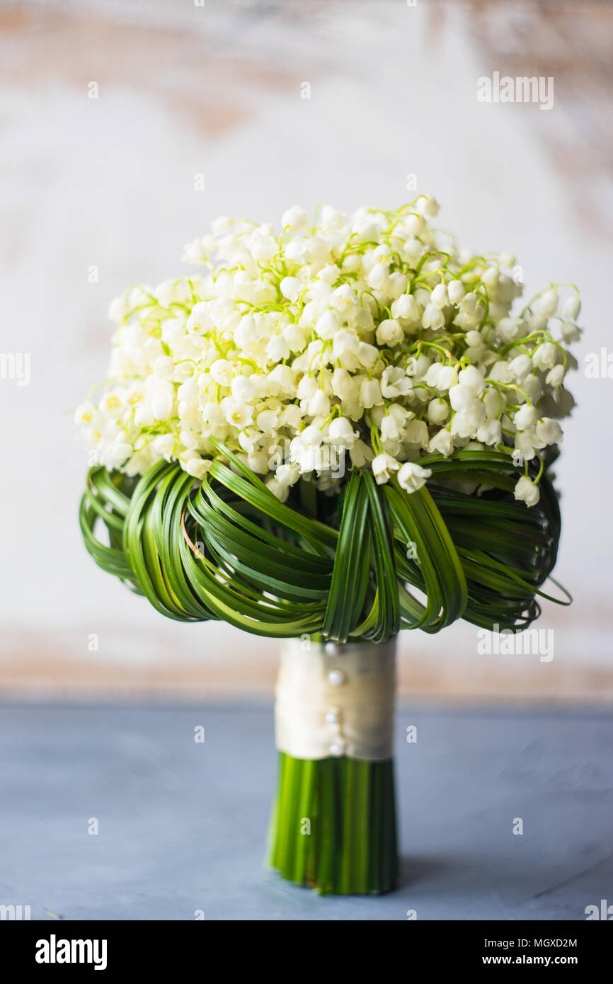 Beautiful may lilies in bride bunch on rustic background with copy ...