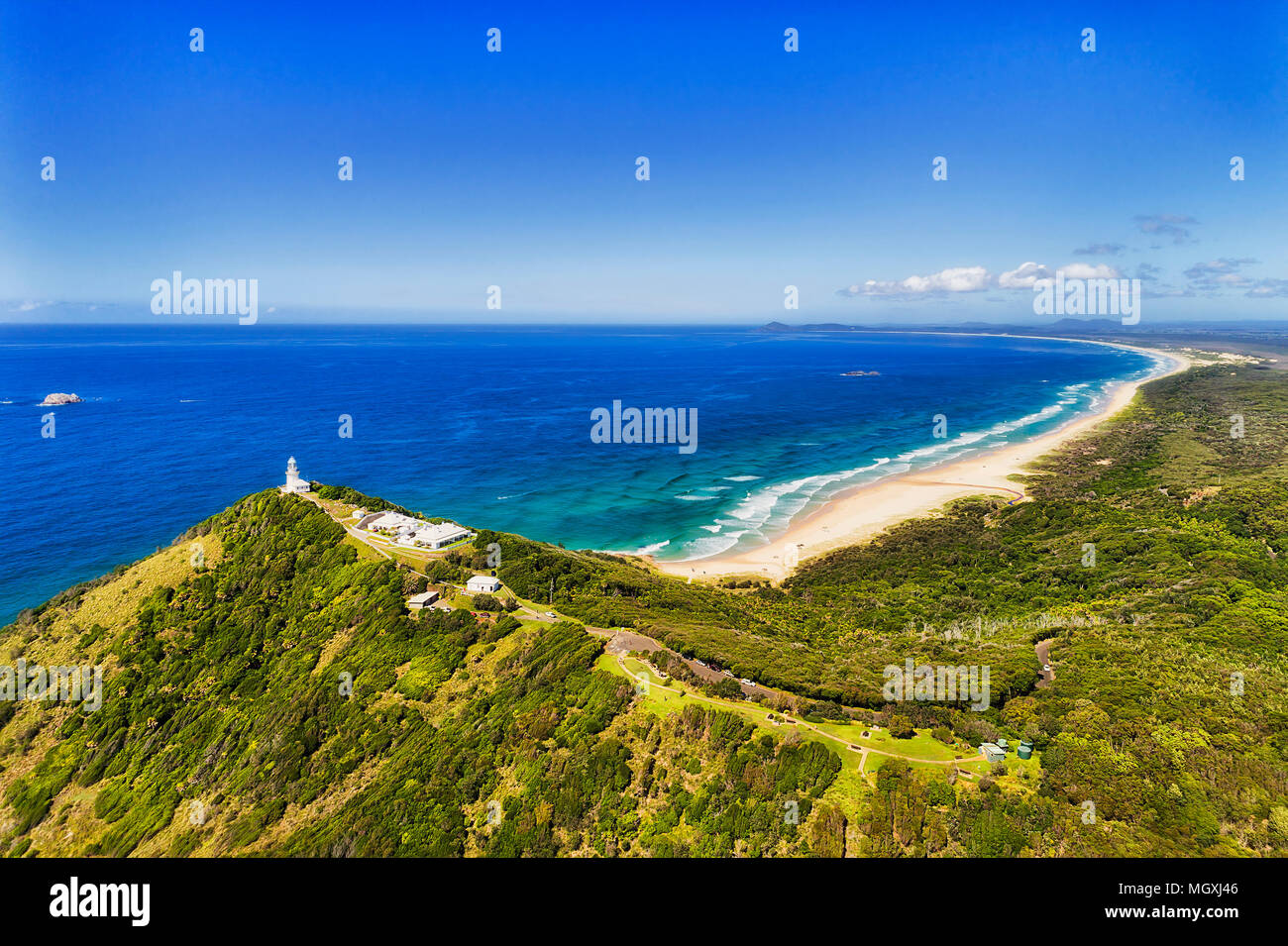 White lighthouse overlooking crystal clear waters of Pacific ocean and ...