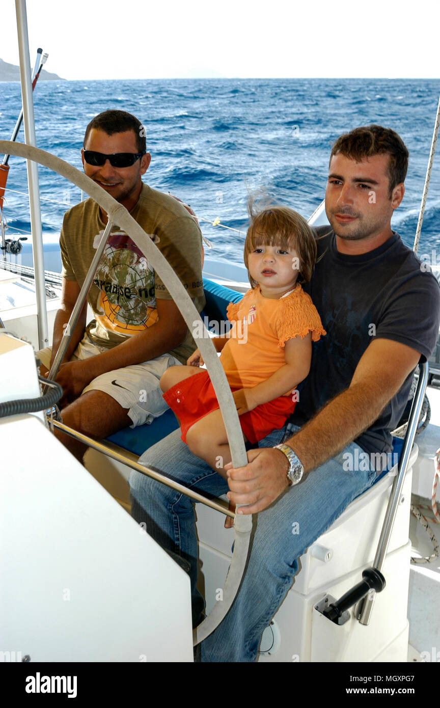 Father and son at the helm of their catamaran, catering for tourist ...