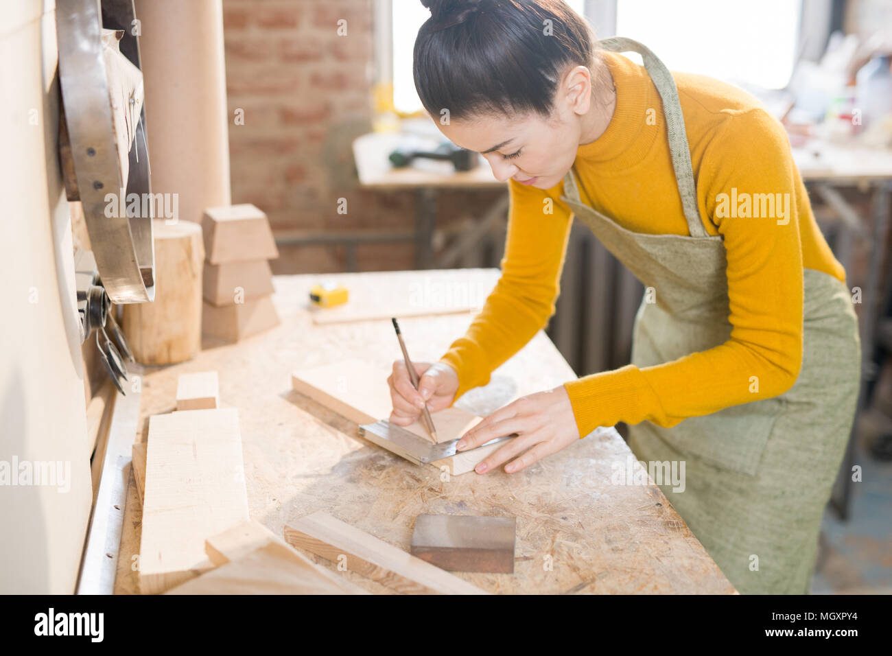 Side view portrait of modern female artisan working with wood in modern ...
