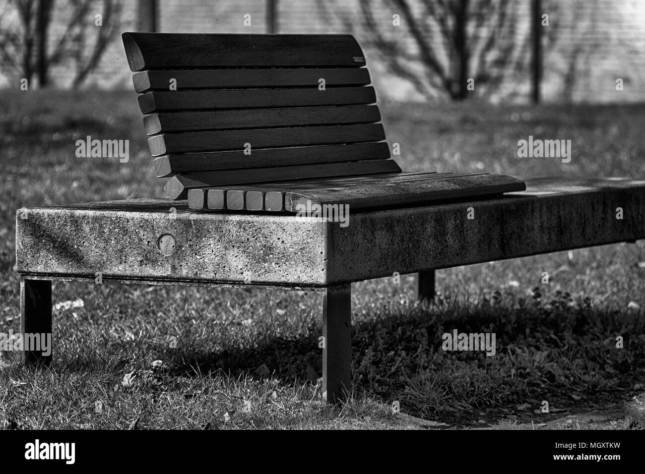 Monochrome Art Bench in public park, loneliness at clear sunny spring ...