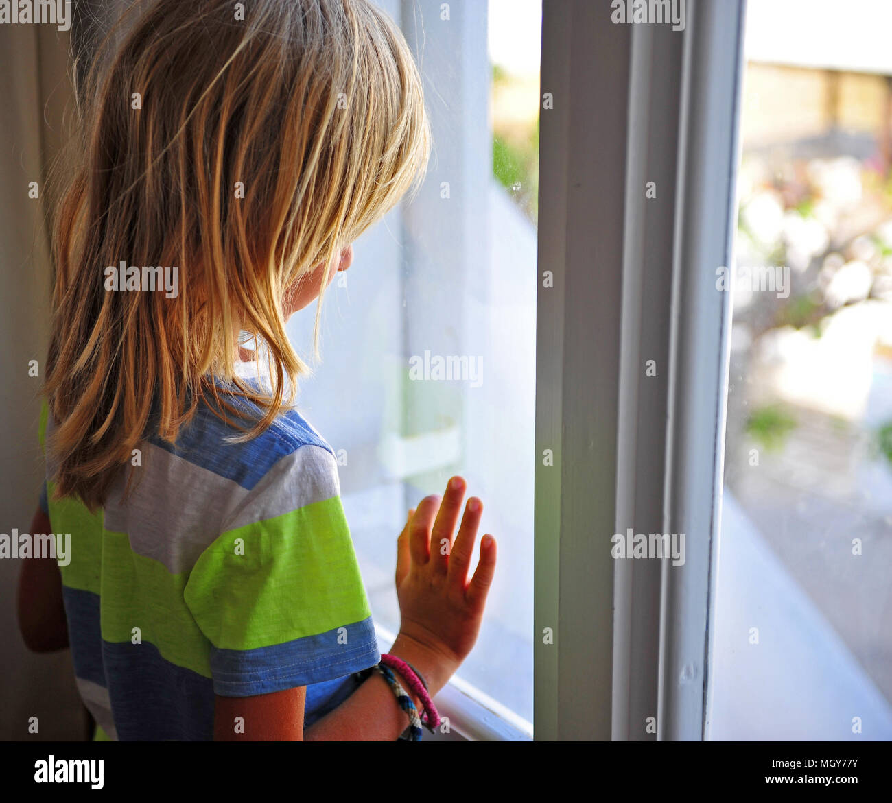 Little boy looking at window Stock Photo - Alamy