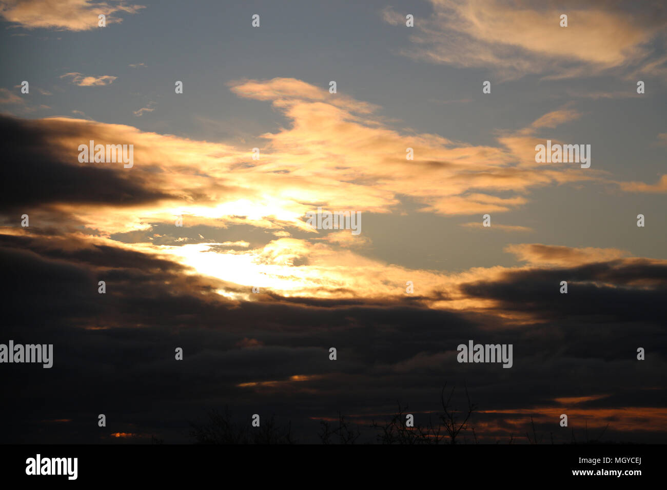 Morning dawn sunrise sky with sun peeping through dark clouds Stock ...