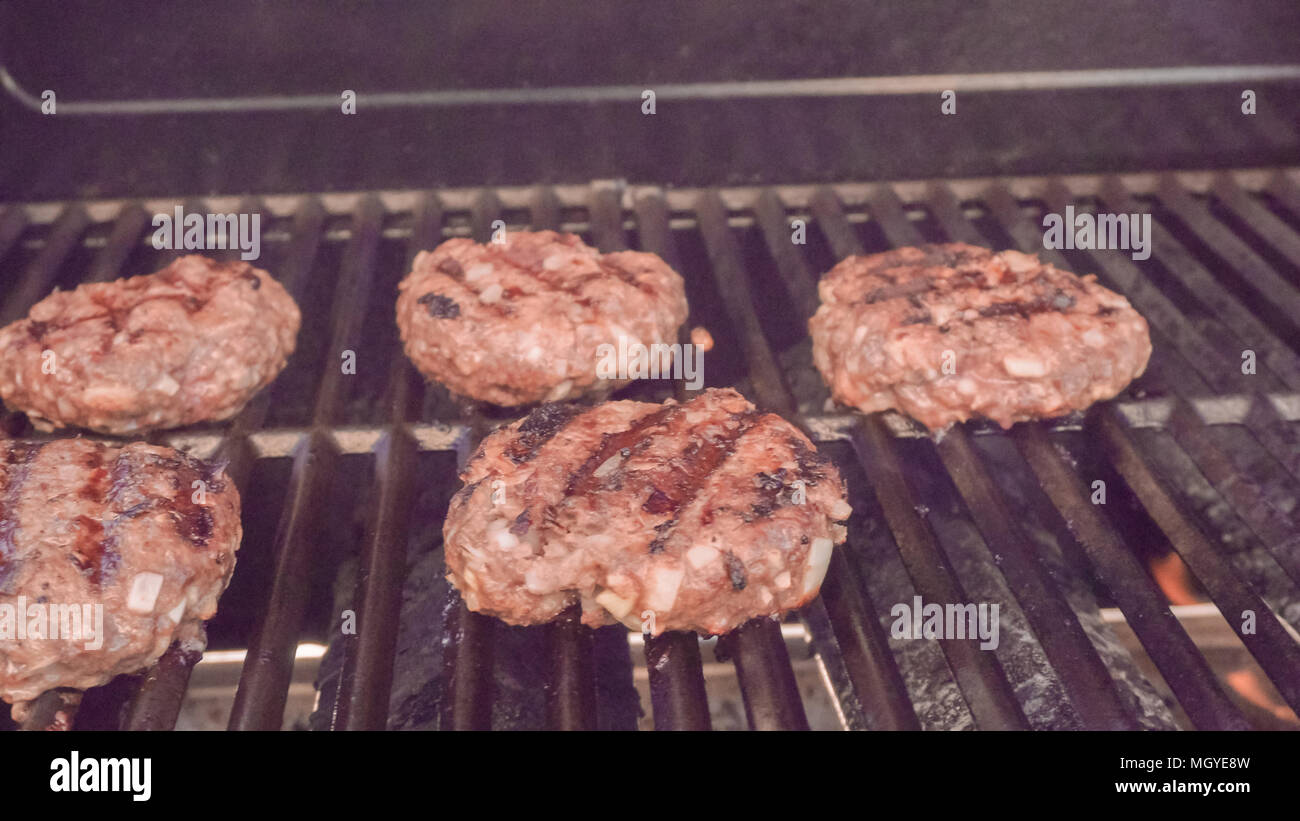 Cooking classic beef burger on outdoor gas grill Stock Photo - Alamy