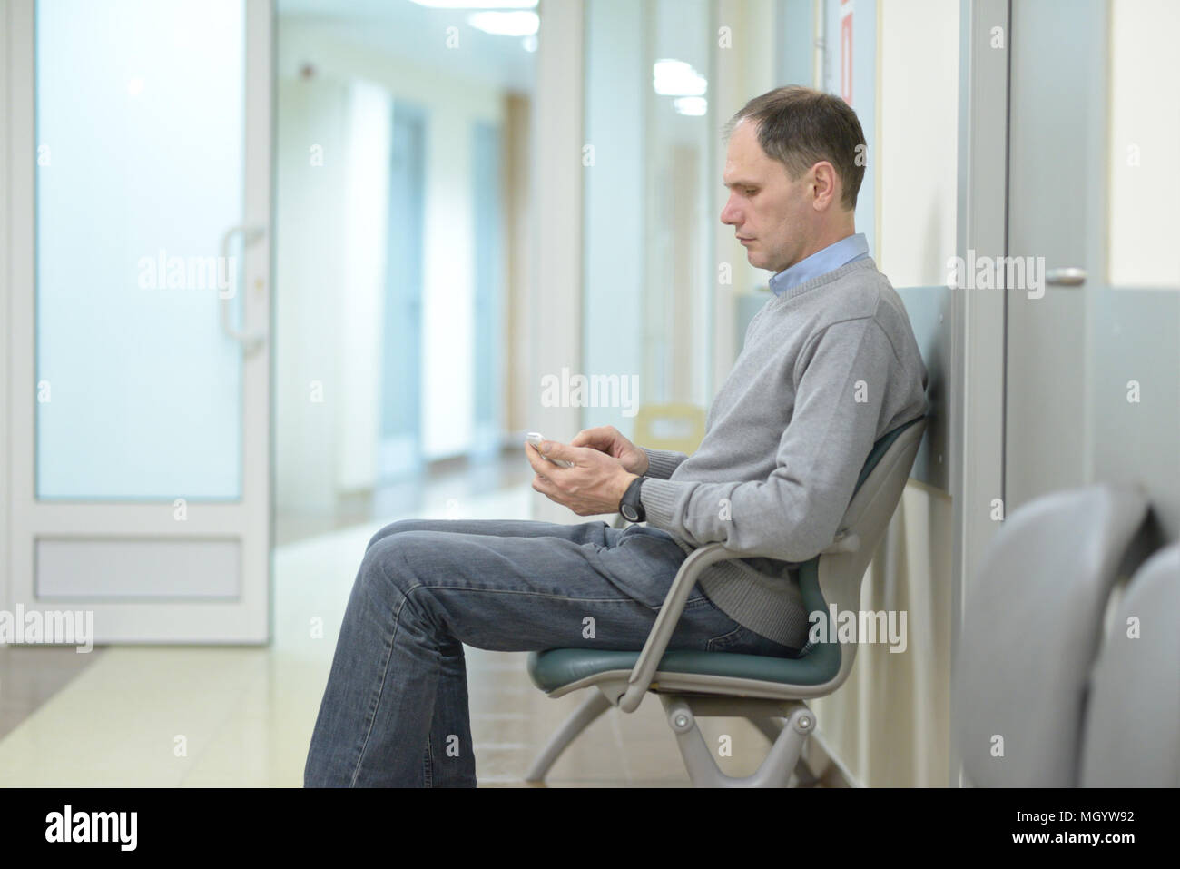 Patient with smartphone waiting for the doctor appointment in the ...
