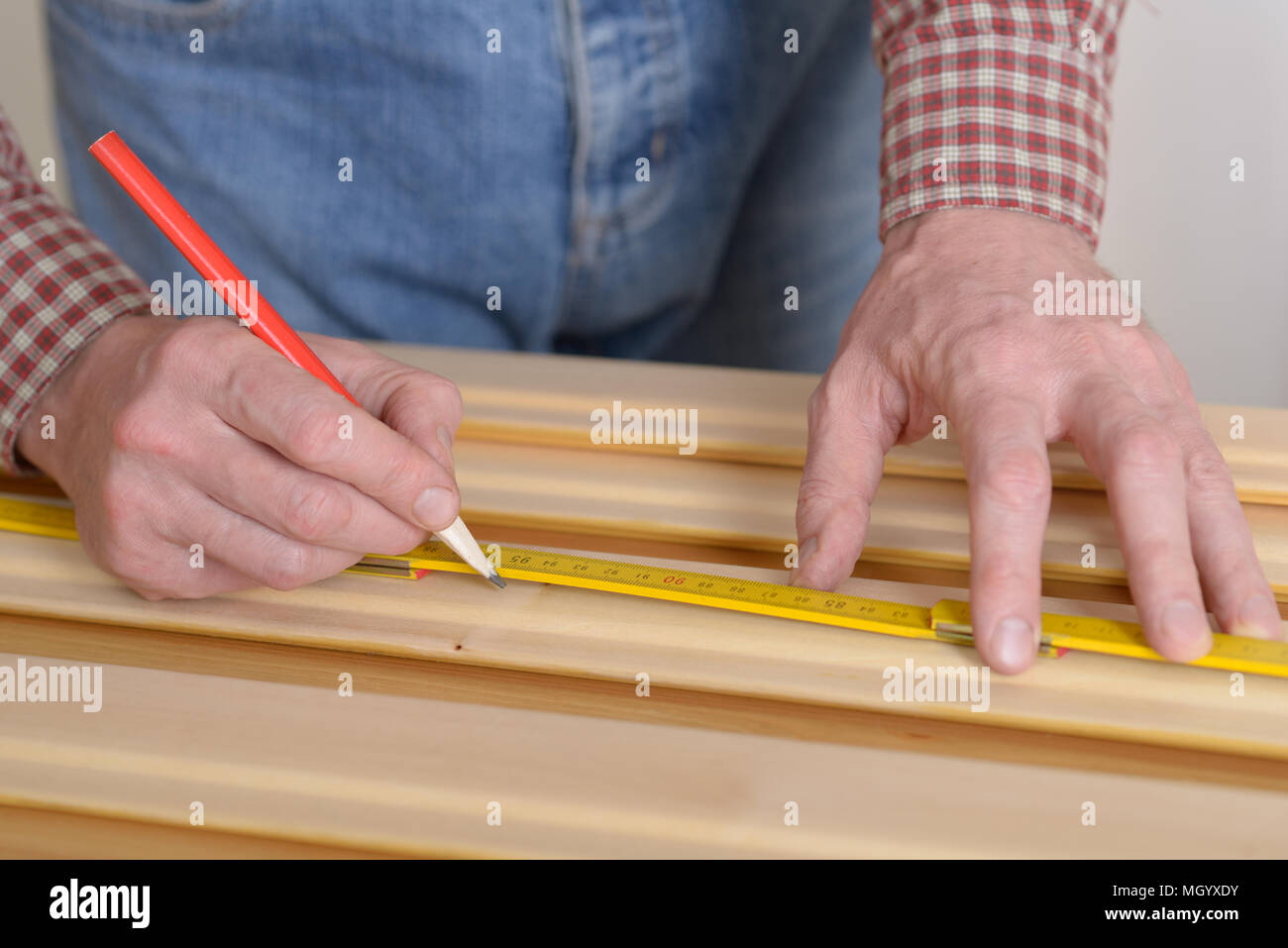 Construction worker marking the wood panel during installation Stock ...