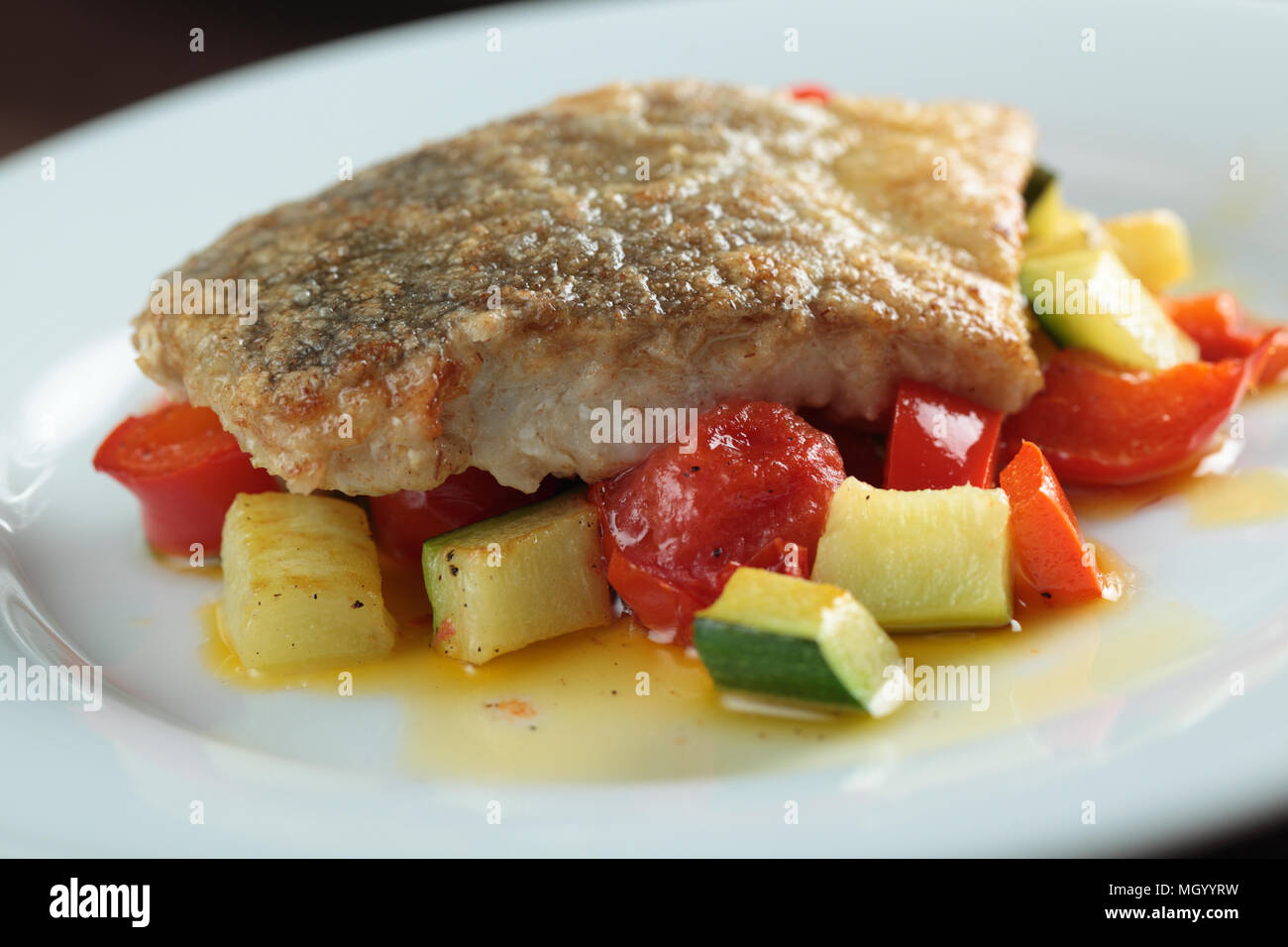 Roasted pollock fillet with zucchini, pepper, and tomatoes Stock Photo ...