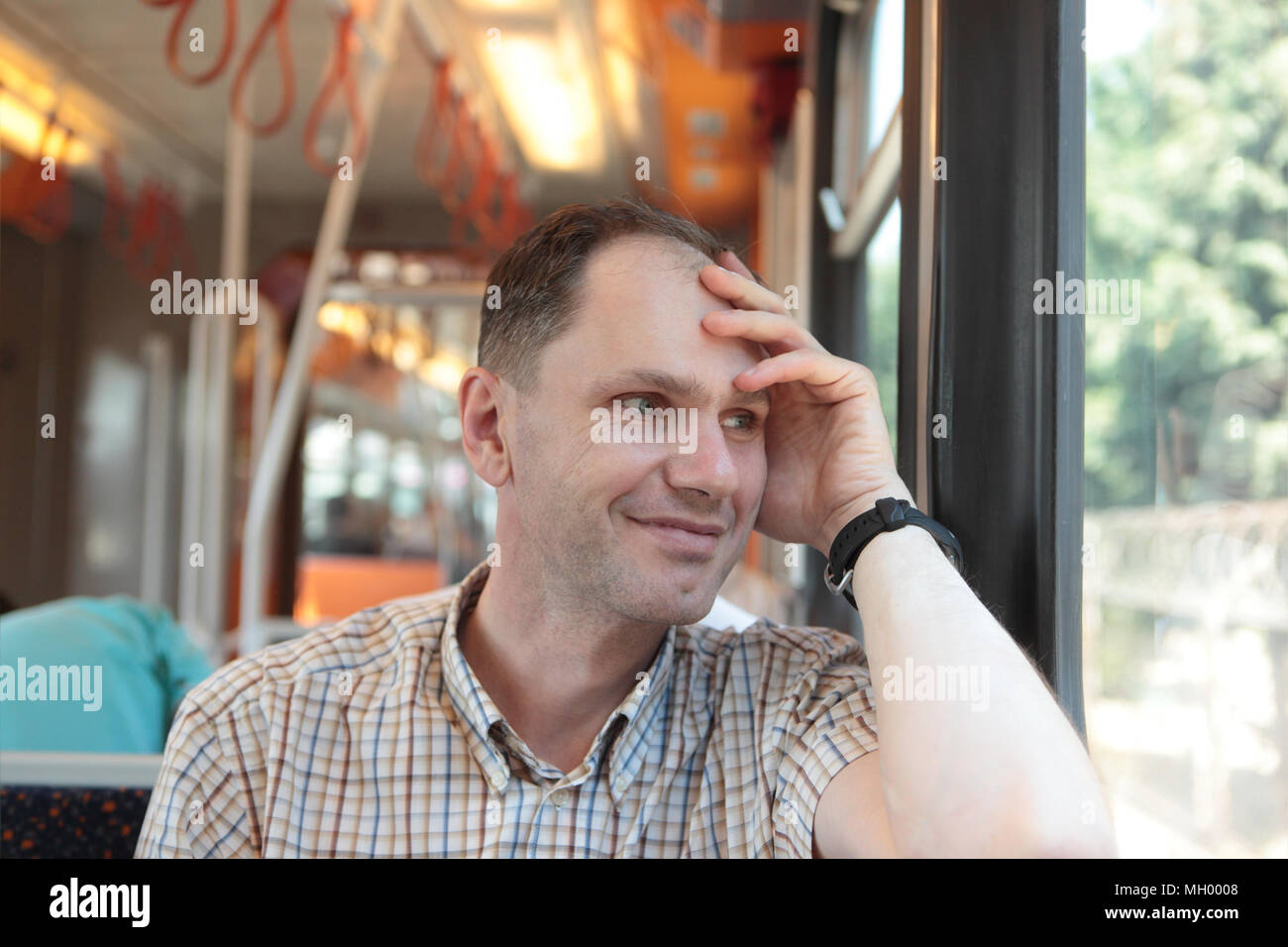 Man in subway train looking into a window Stock Photo - Alamy