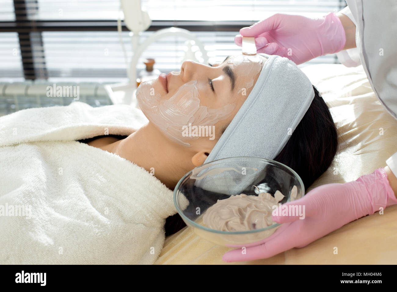 Cosmetologist Applying Face Mask Side View Stock Photo - Alamy