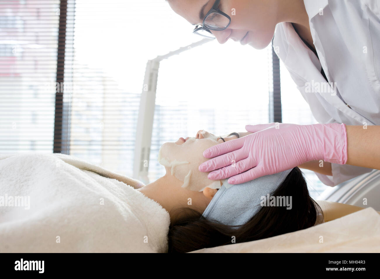 Professional aesthetician performing facial treatment hi-res stock ...