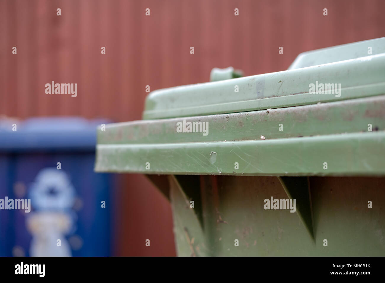 Close up, shallow focus of a green plastic wheelie bin used for organic ...