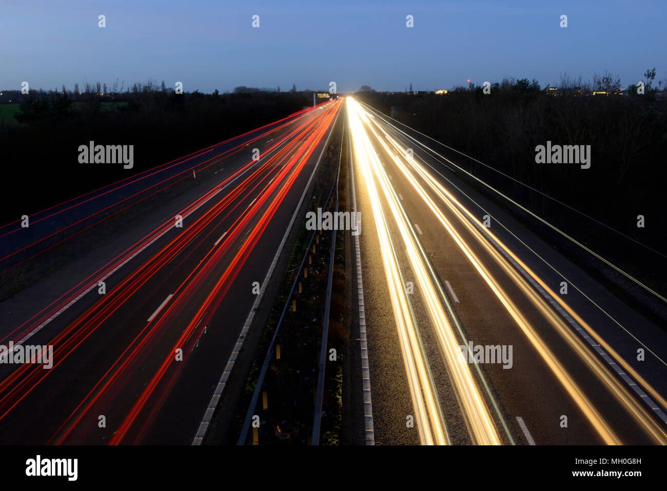 White headlights and red tail-lights on motorway at night in motion ...