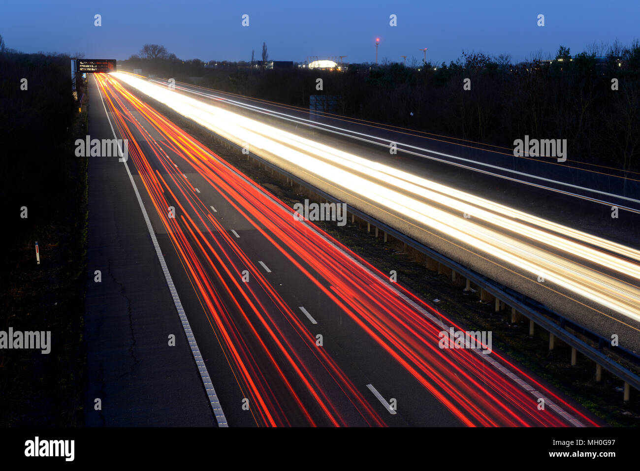 White headlights and red tail-lights on motorway at night in motion ...