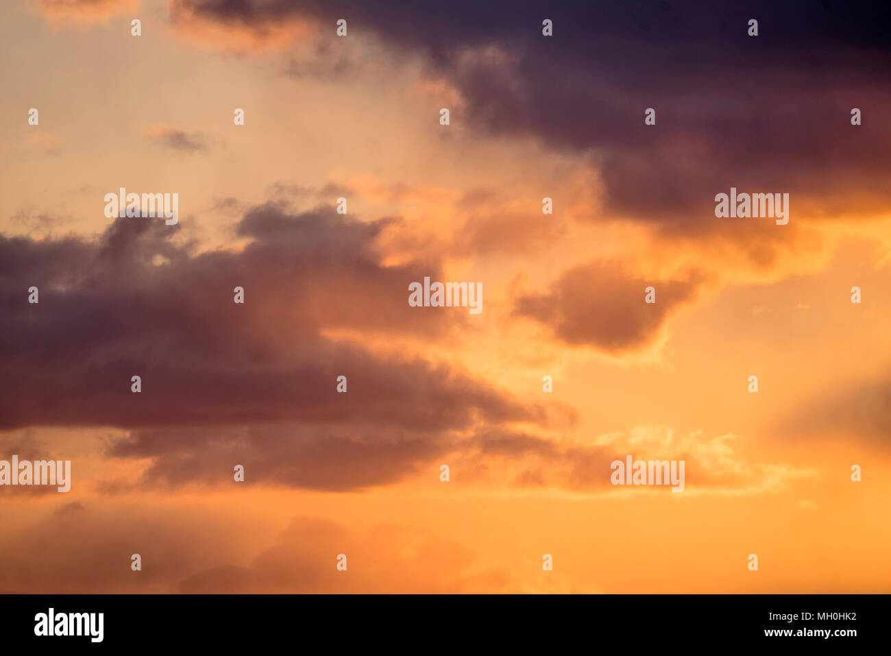 Sunset in beautiful colors with clouds covering the sun in the sky ...