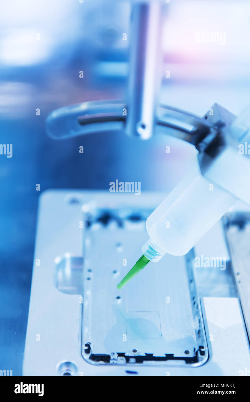 Robot holding glue syringe Injection in mobile phone factory Stock ...