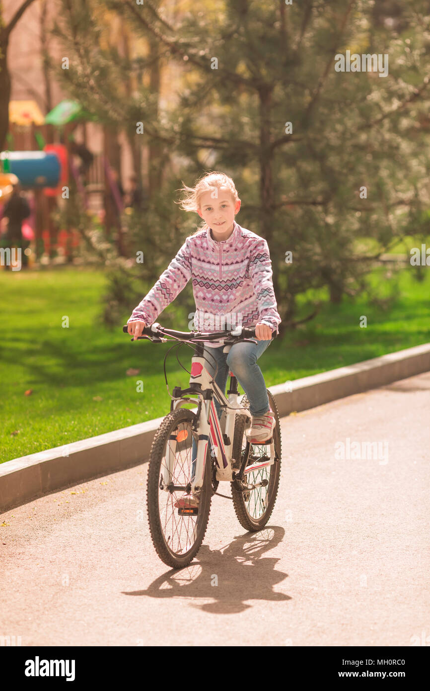 Happy little girl riding a bike in the park Stock Photo - Alamy