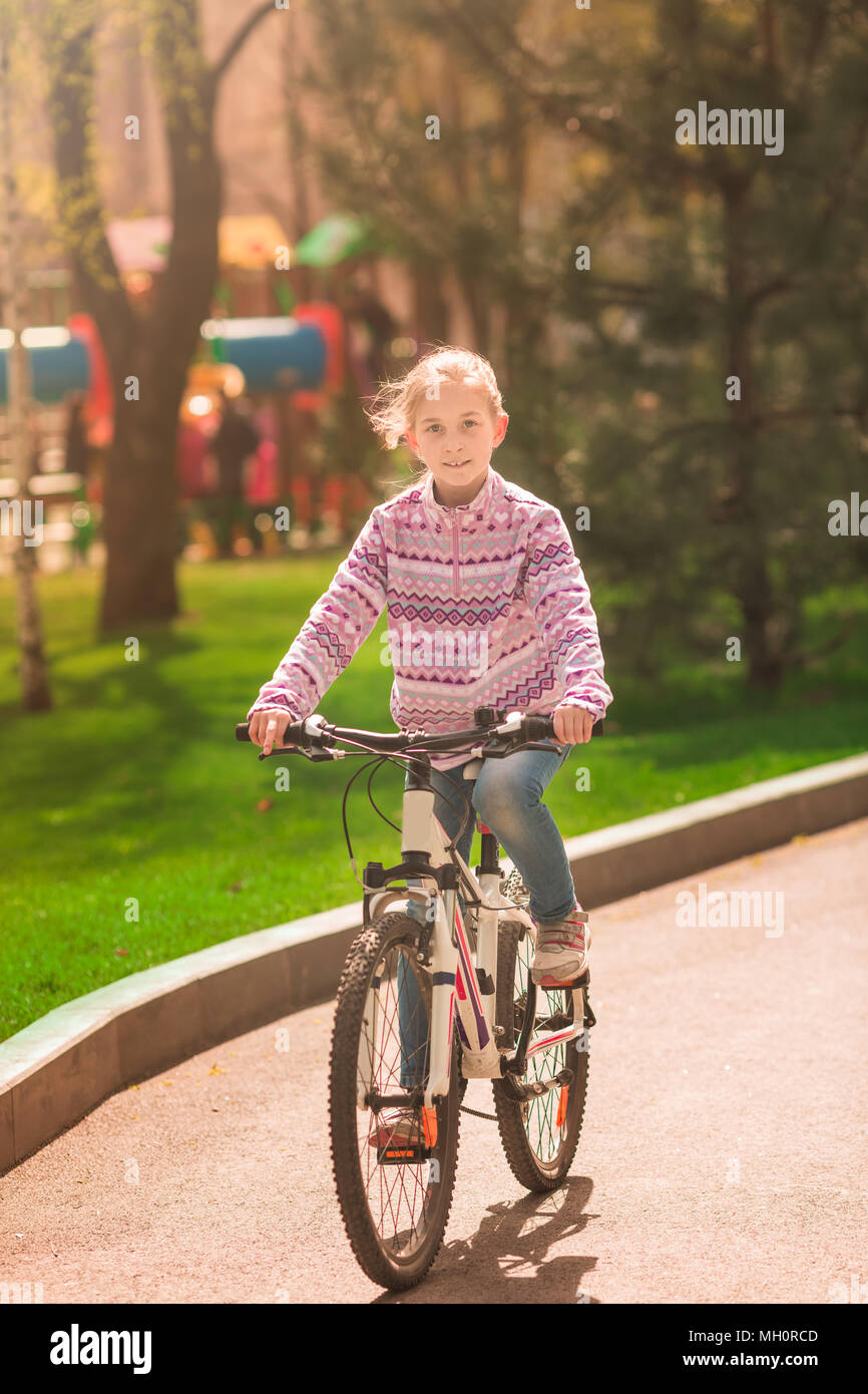 Happy little girl riding a bike in the park Stock Photo - Alamy
