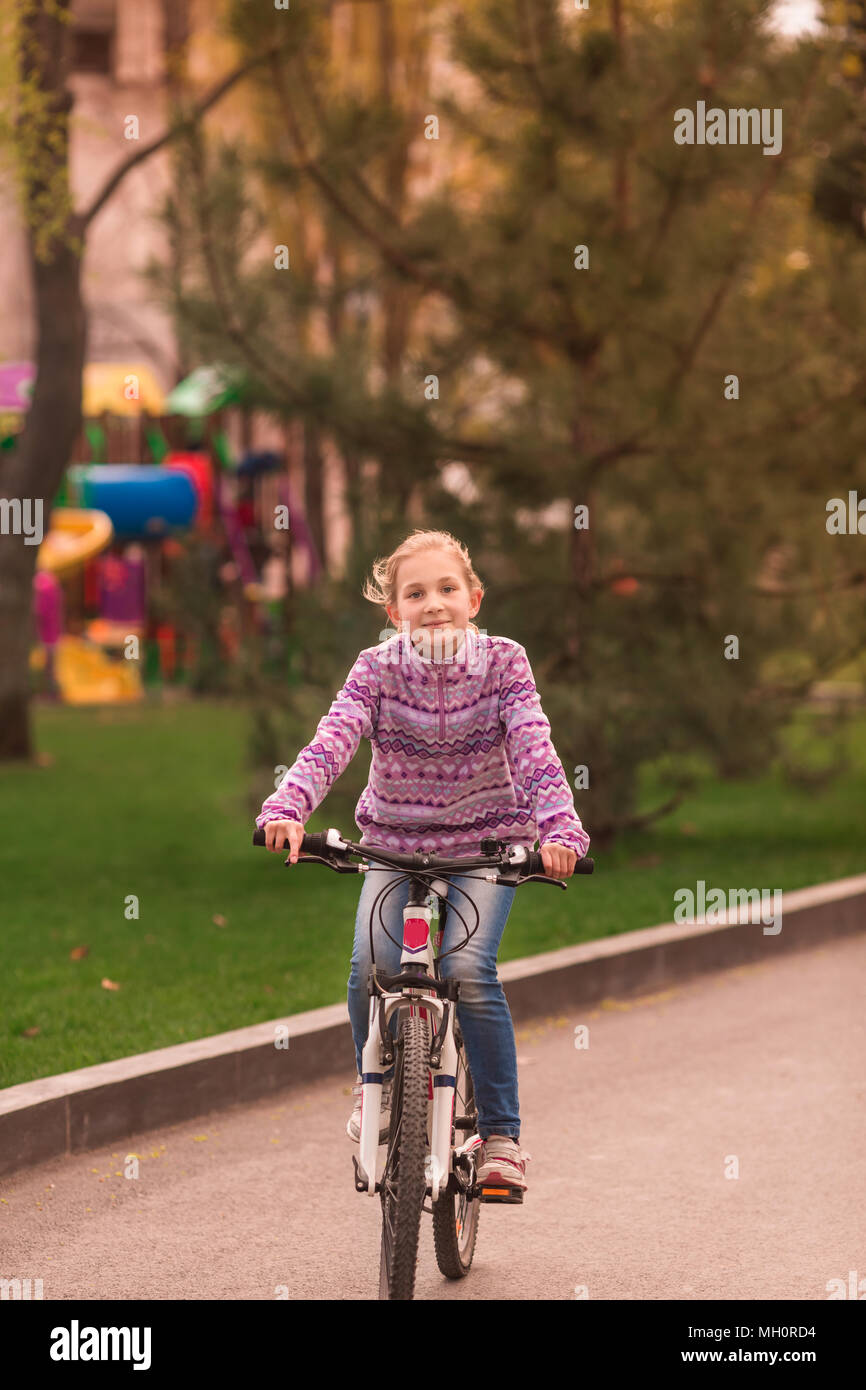 Happy little girl riding a bike in the park Stock Photo - Alamy