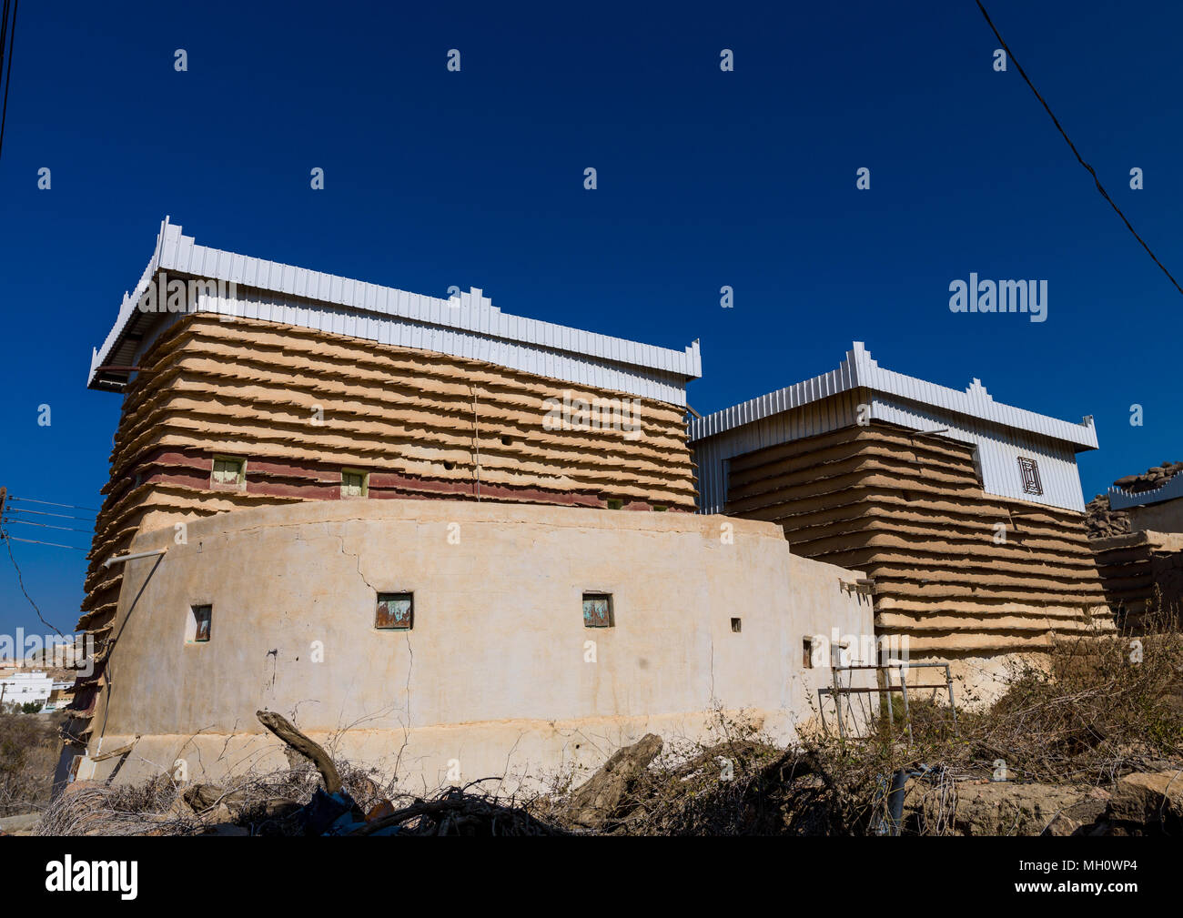 Traditional clay and silt home with a modern roof in a village, Asir ...