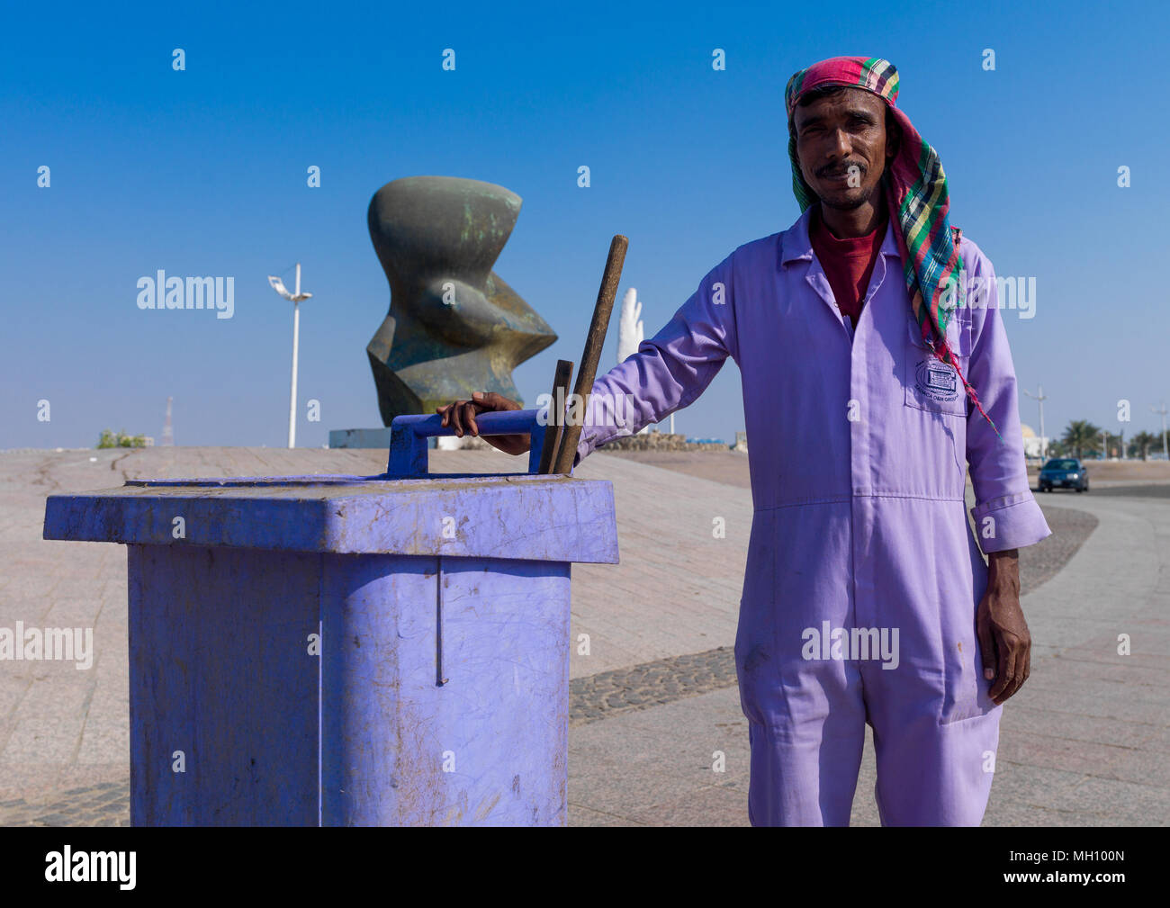 Pakistani worker with a bin near modern art on the corniche, Hijaz ...
