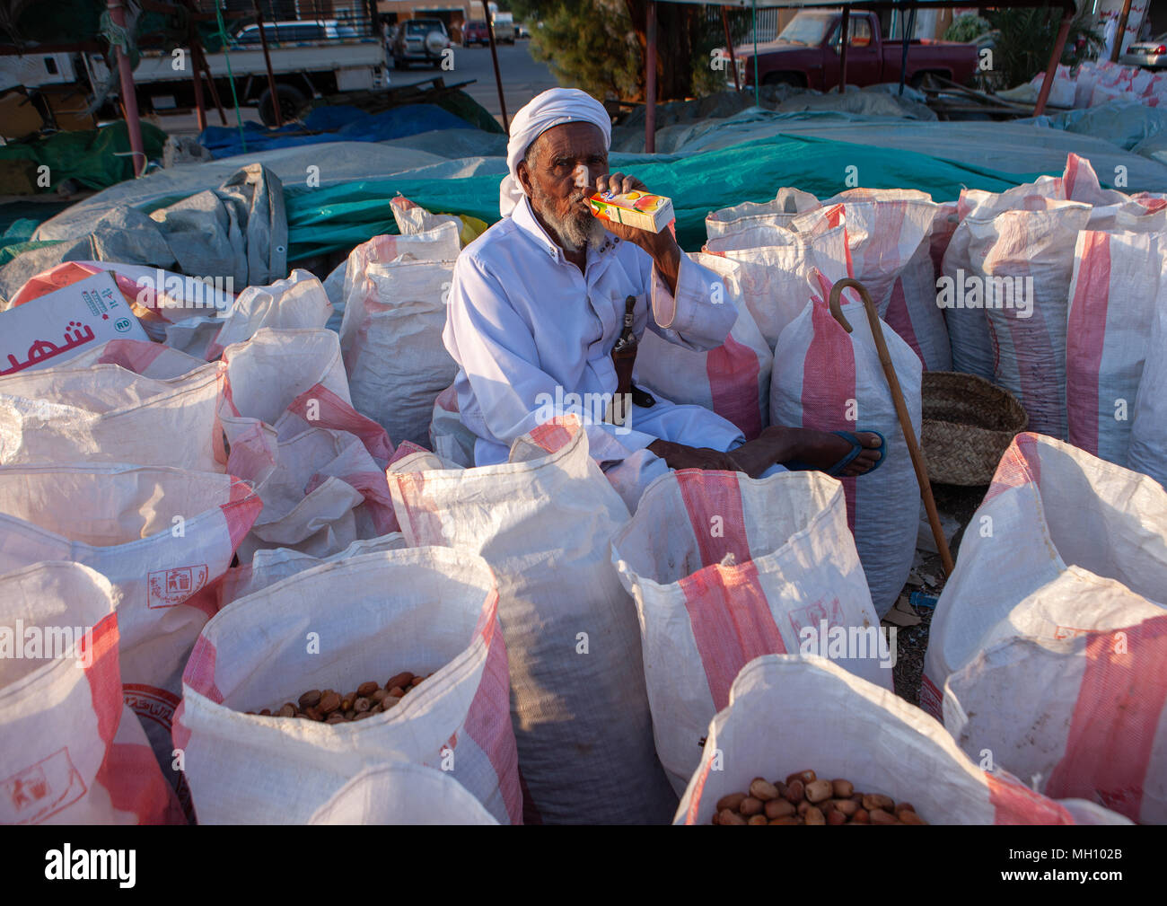 Saudi man drinking juice while selling dates in the market, Najran ...