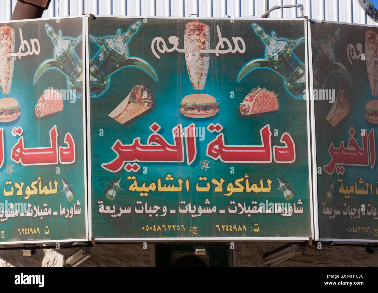A painted sign advertising for a fast food restaurant, Al-Jawf Province ...
