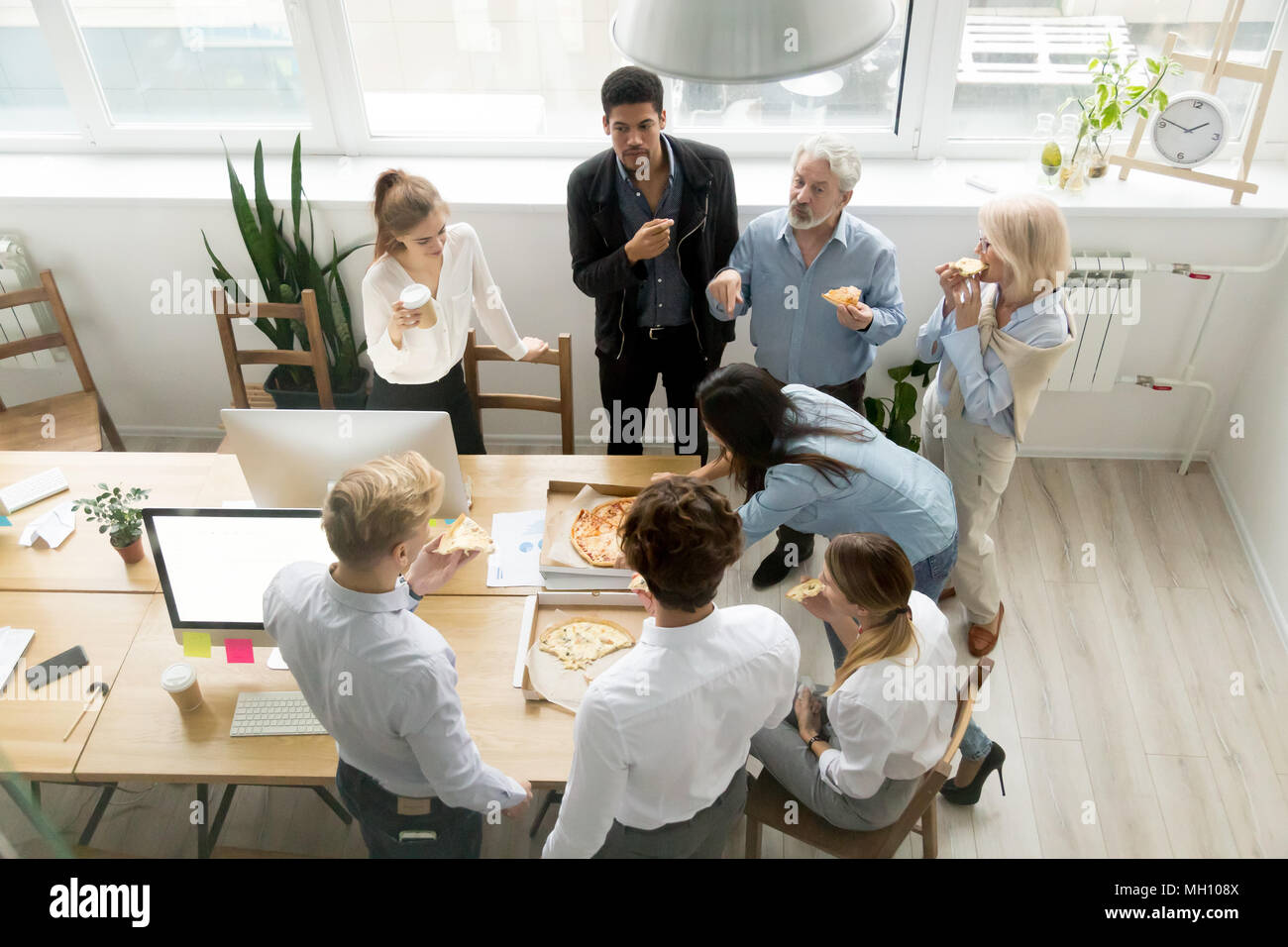 Diverse business team eating pizza together in office, top view Stock ...