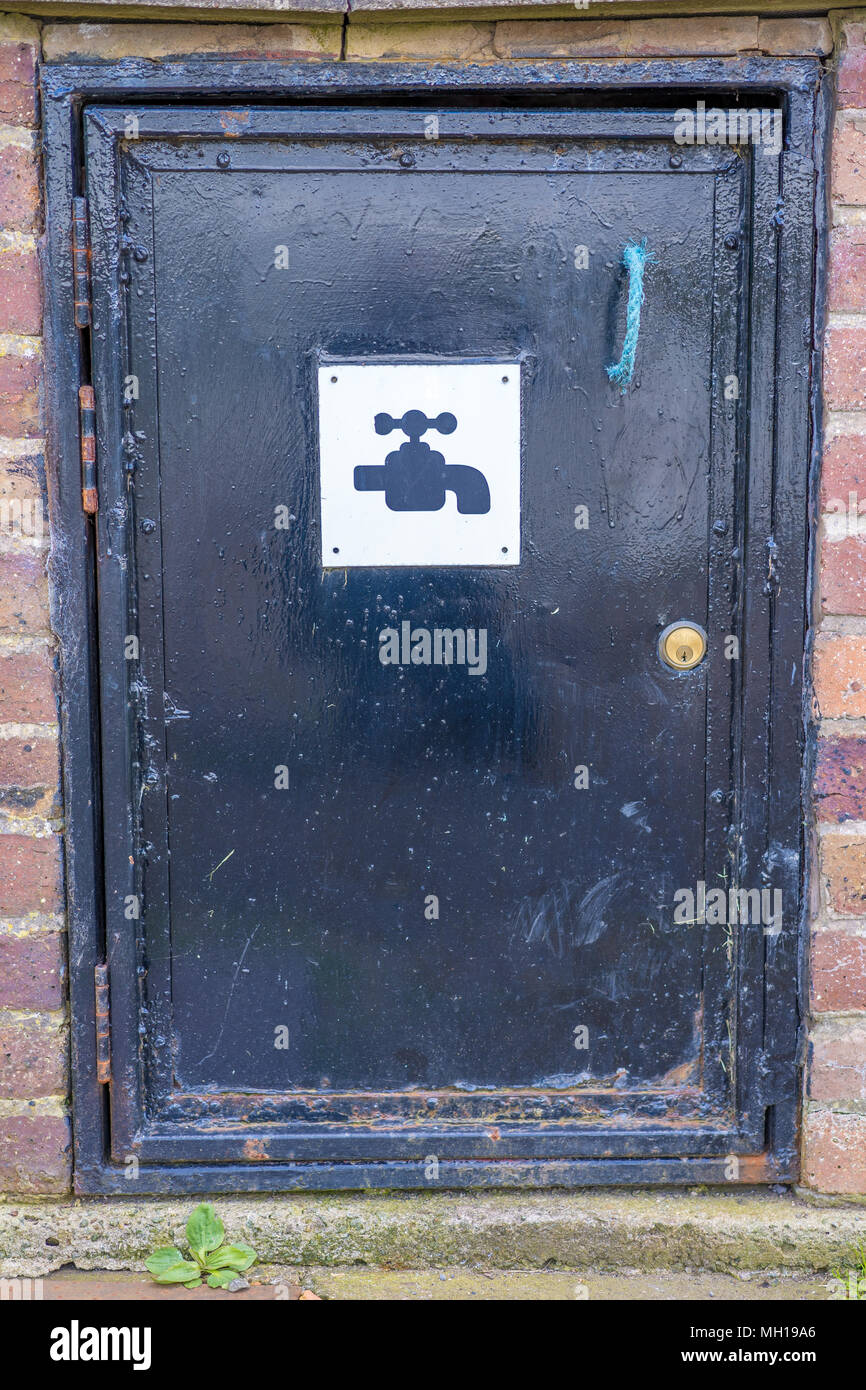 Water tap sign on old black door Stock Photo - Alamy