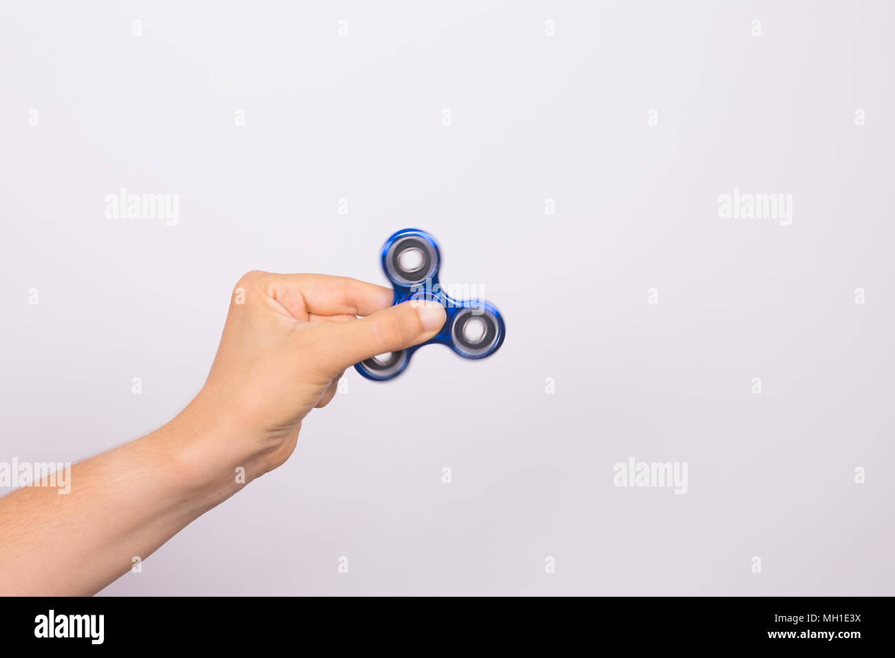 male hand holding popular fidget spinner toy on white background with ...