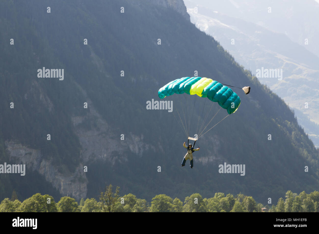 Basejumper soaring with parachute open in Lauterbrunnen Switzerland ...