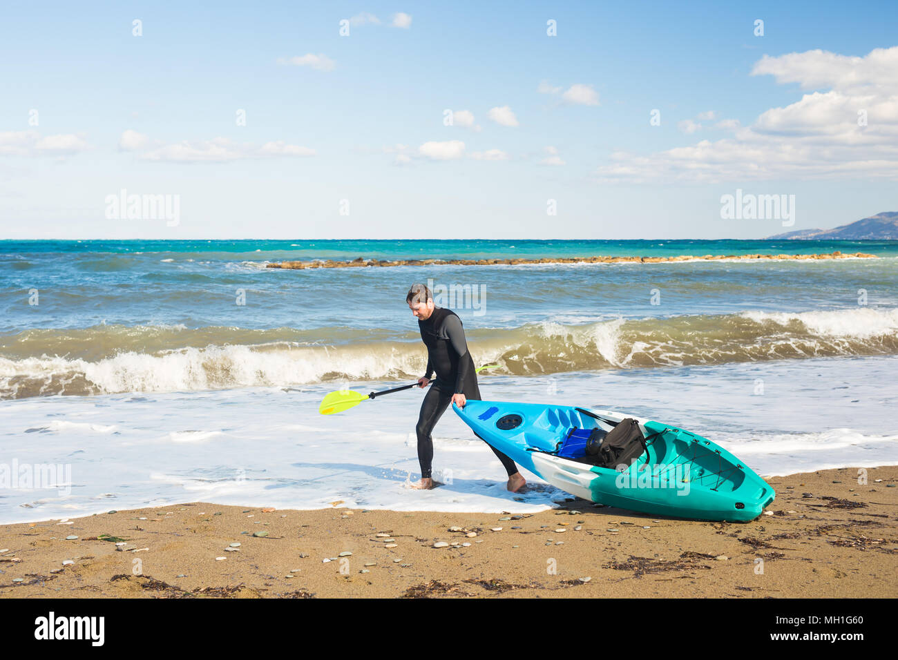 man carrying kayak at sea beach Stock Photo - Alamy