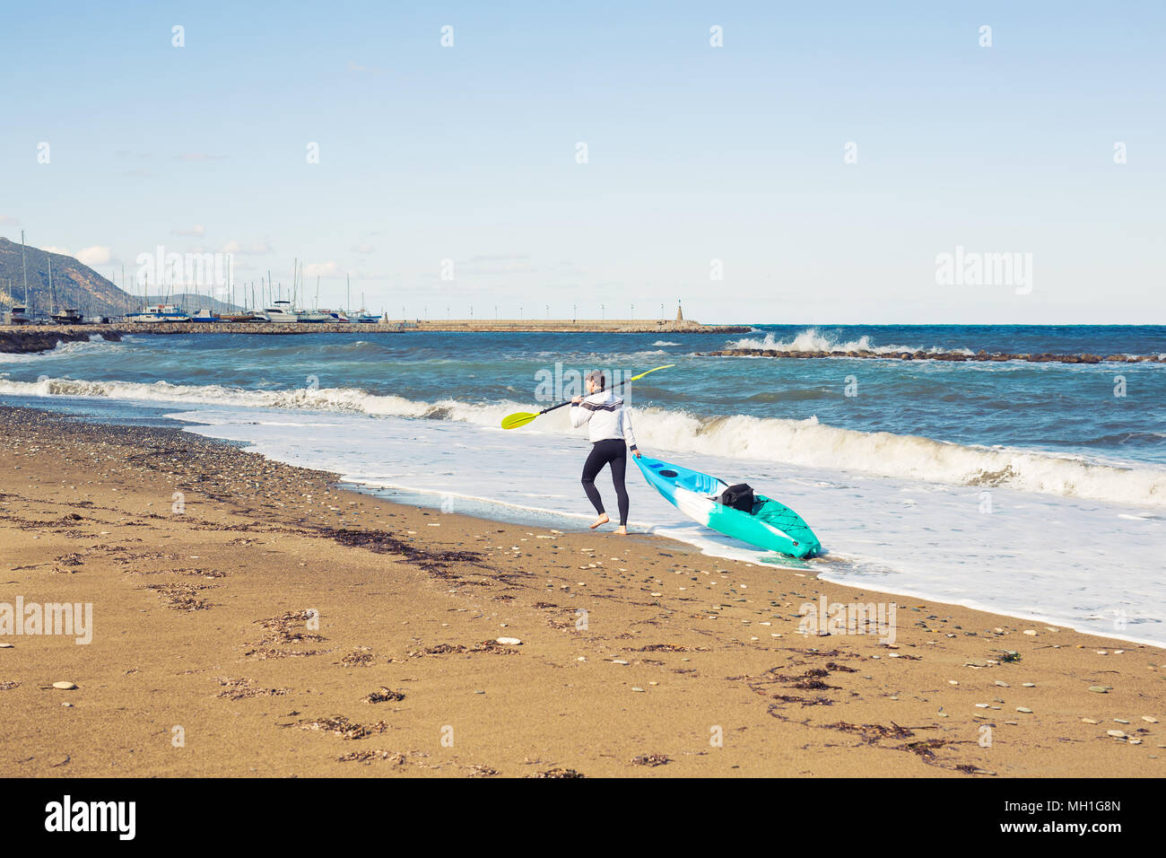 man carrying kayak at sea beach Stock Photo - Alamy