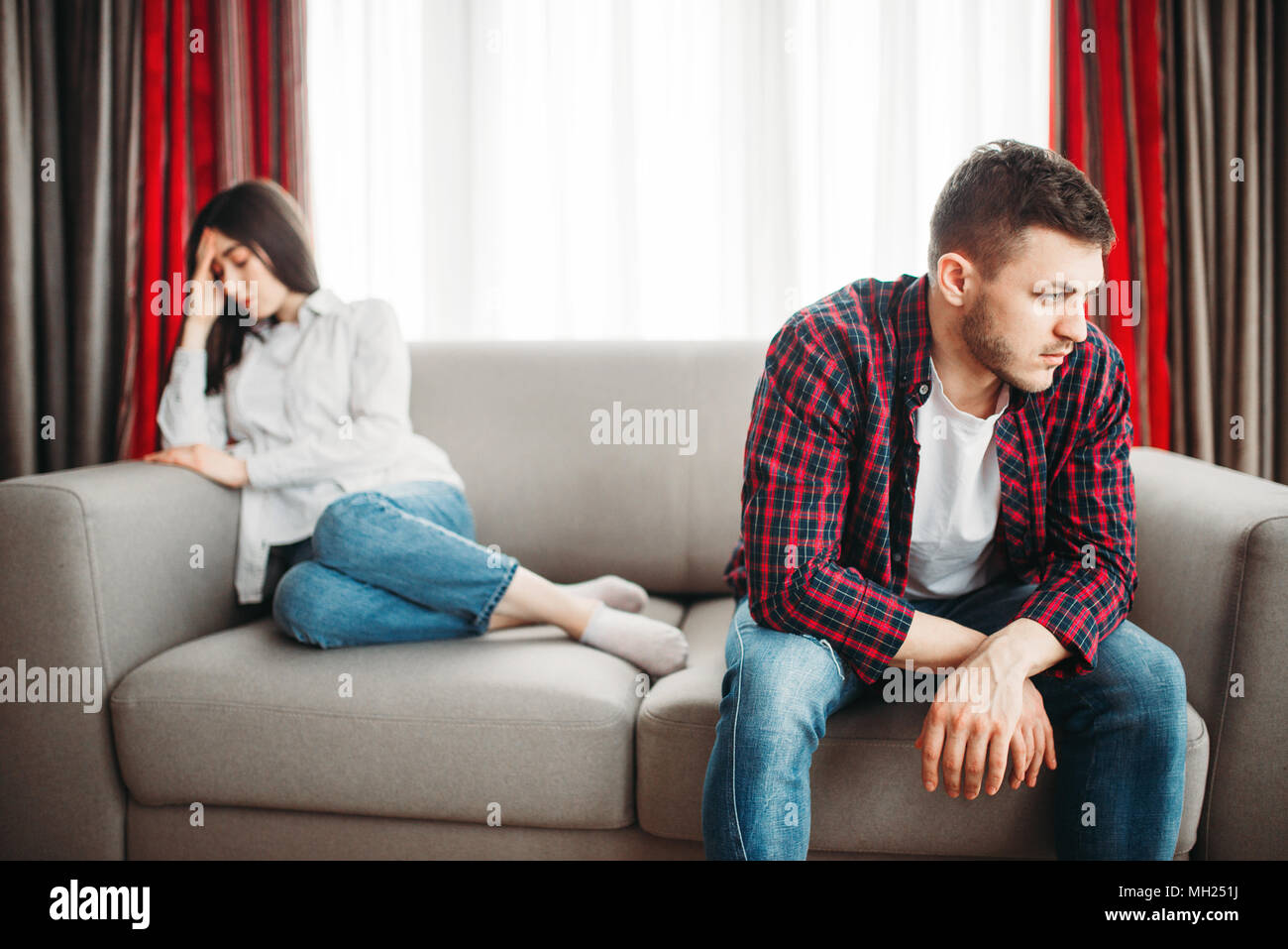 Stressed couple sitting on couch, family conflict Stock Photo - Alamy