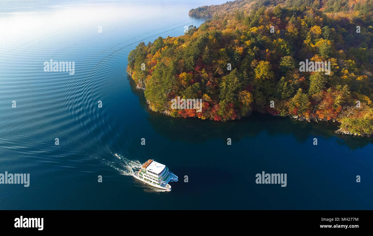 Aerial view of a ferry traveling across volcanic Lake Towada, Japan ...