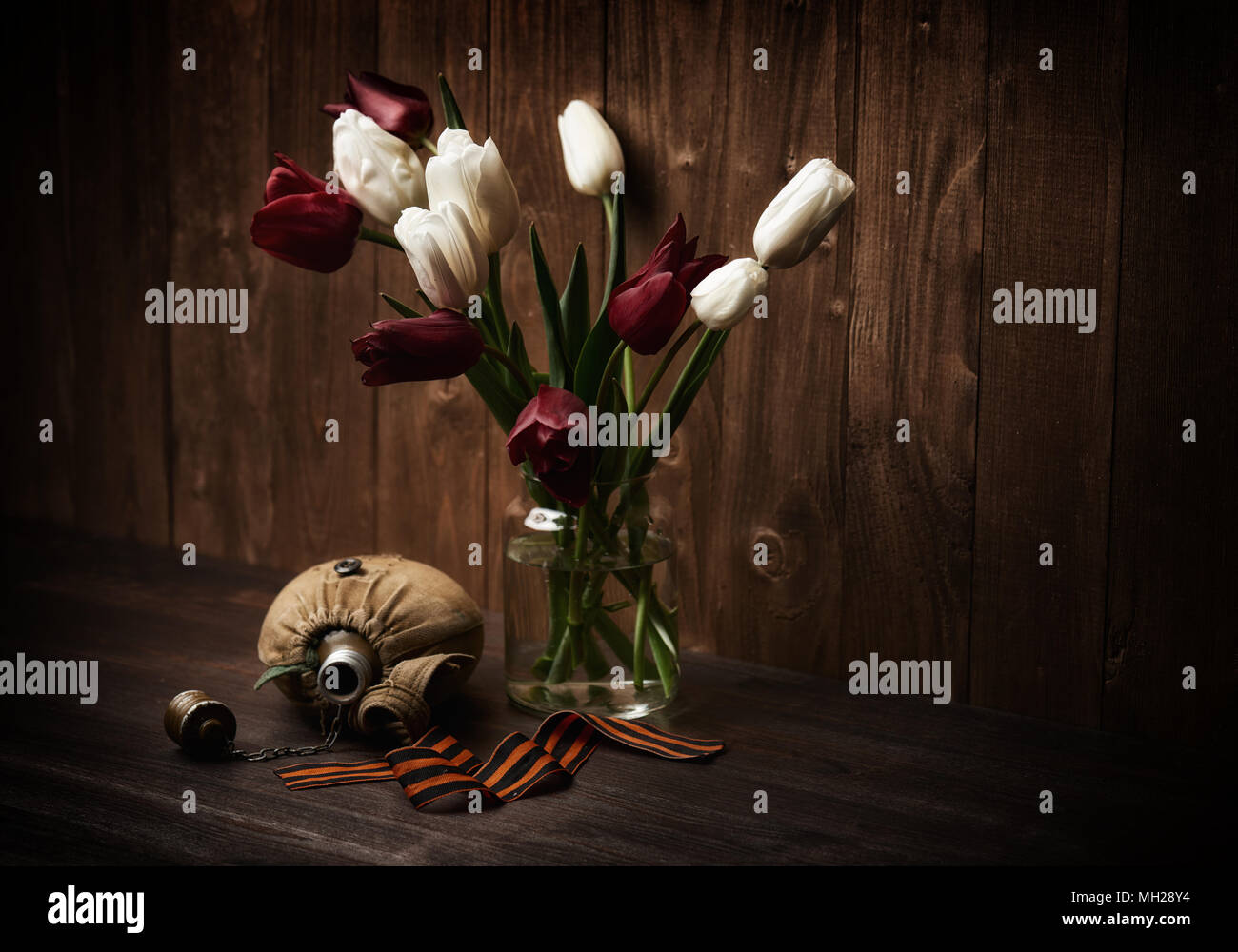 old soldier's flask and St. George's ribbon on dark wooden background ...